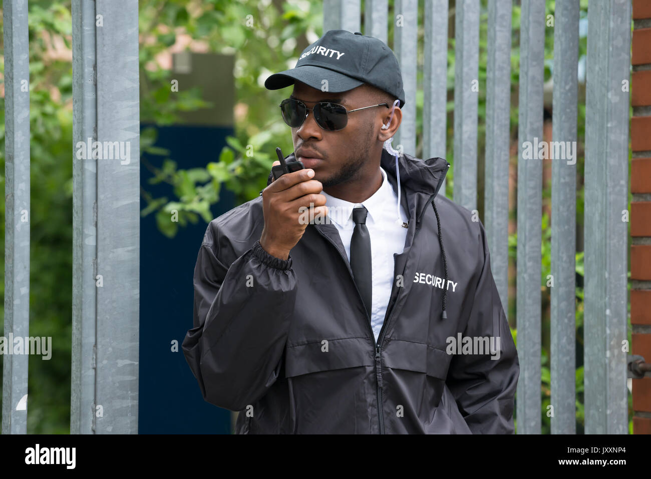 Young Male Security Guard In Black Uniform Using Walkie-Talkie Stock ...