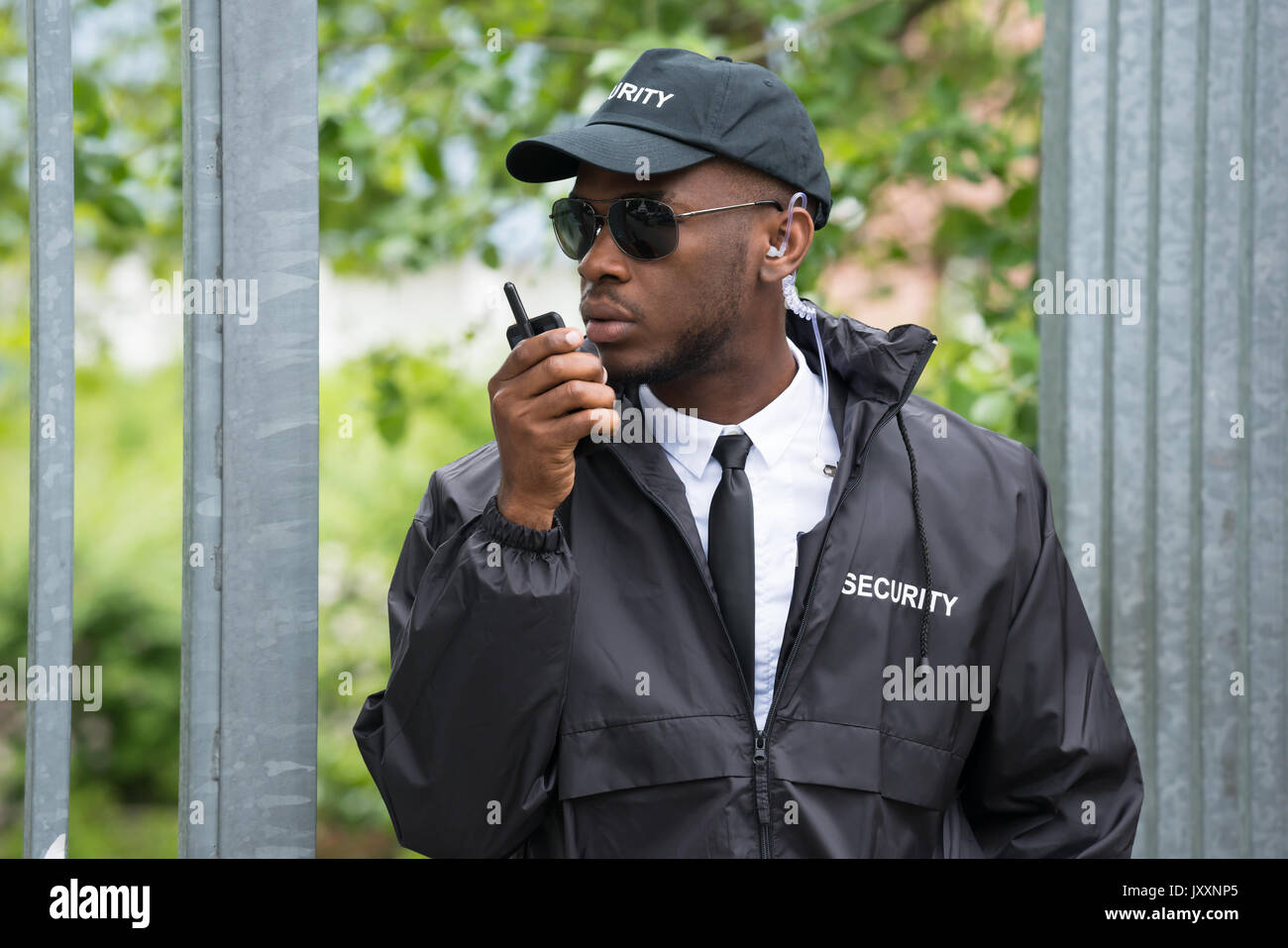 Young Male Security Guard In Black Uniform Using Walkie-Talkie Stock ...