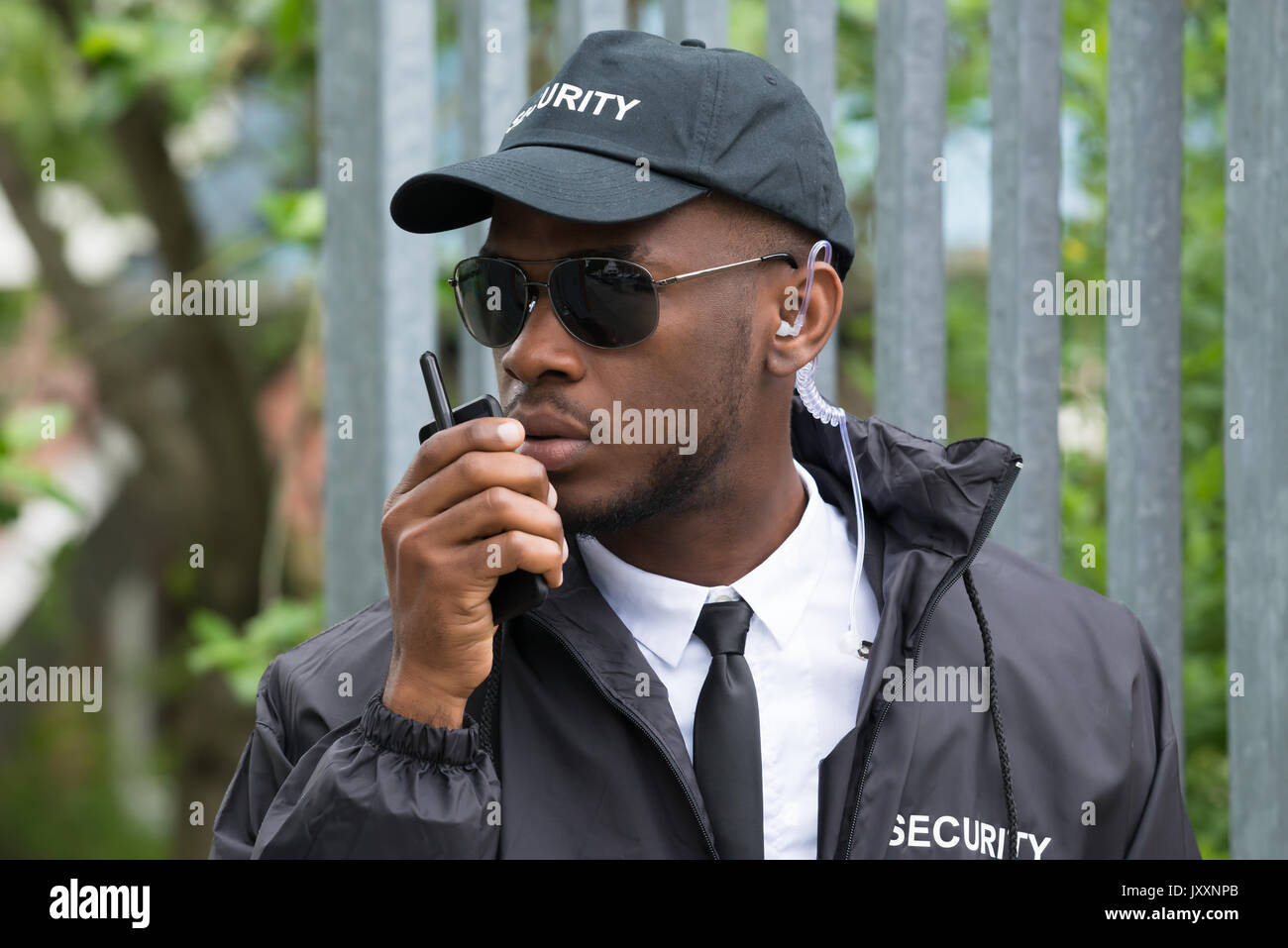 Young Male Security Guard In Black Uniform Using Walkie-Talkie Stock ...