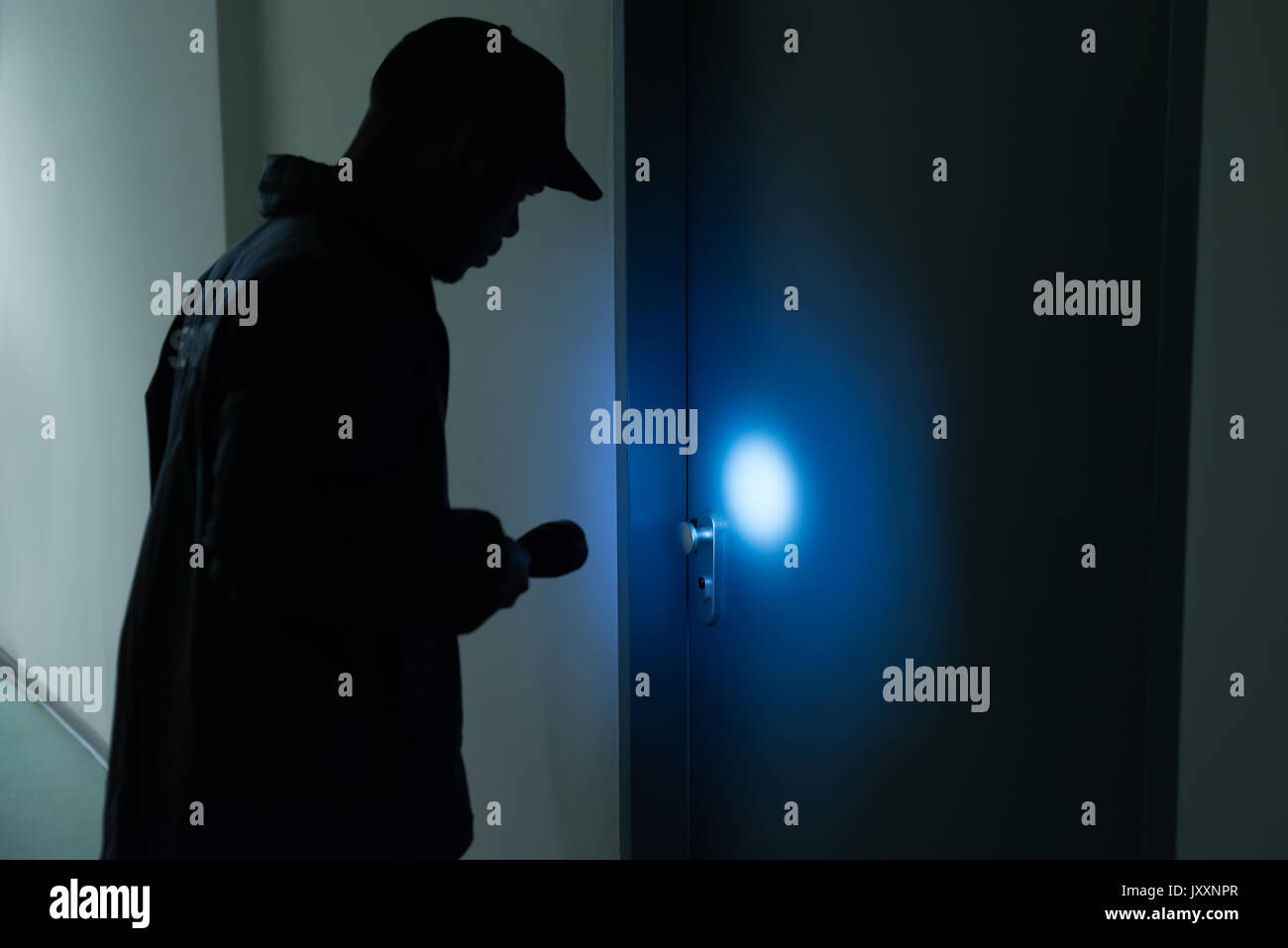 Male Security Guard With Flashlight Standing In Front Of Door Stock ...