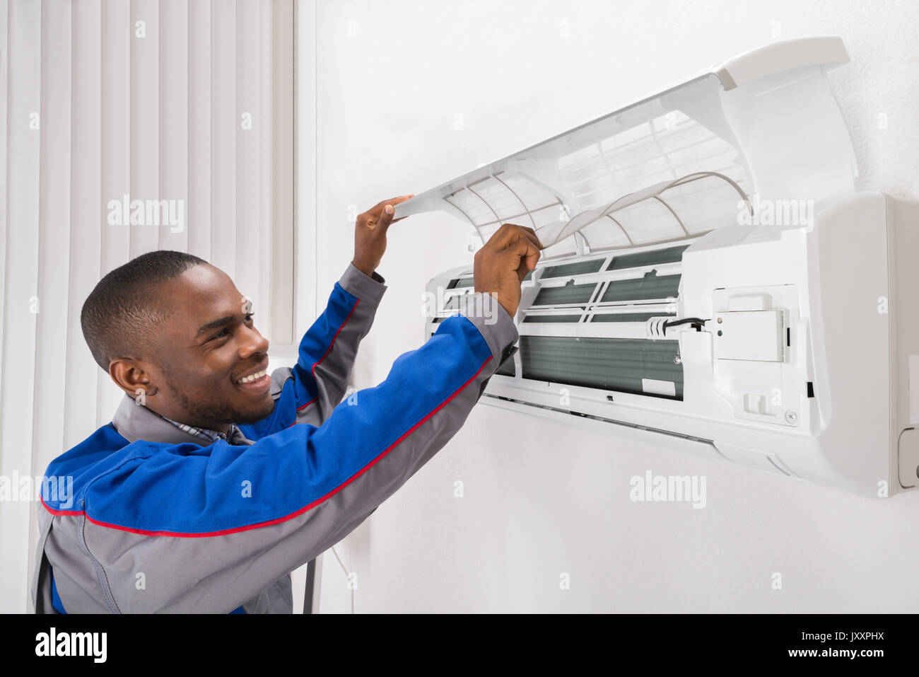 Happy Male Technician Checking Air Conditioner At Home Stock Photo - Alamy