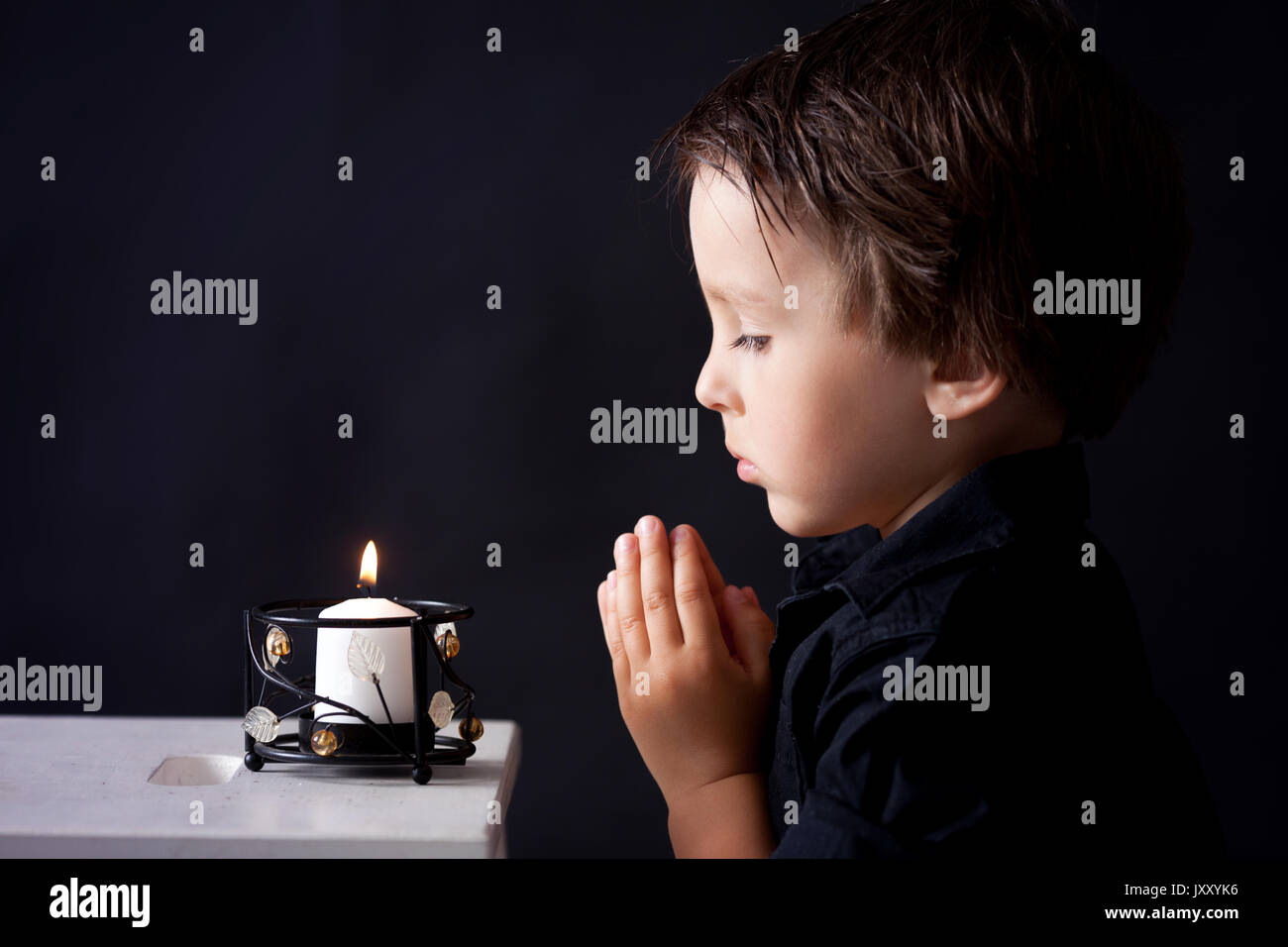 Little boy praying, child praying, isolated black background Stock ...