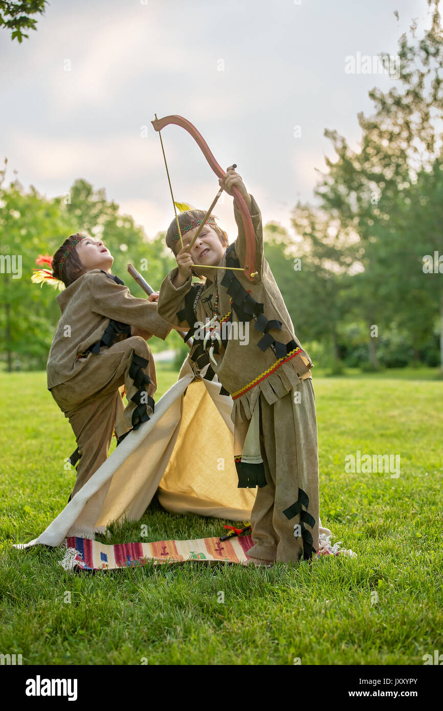 Cute portrait of native american boys with costumes, playing outdoor in ...