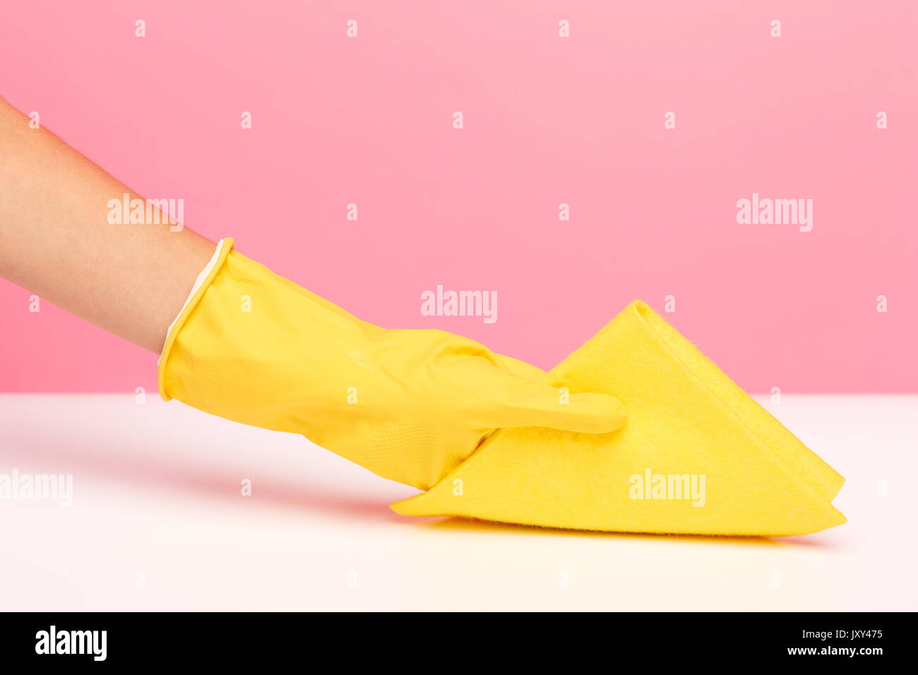 The woman's hand cleaning on a pink background. Cleaning or ...