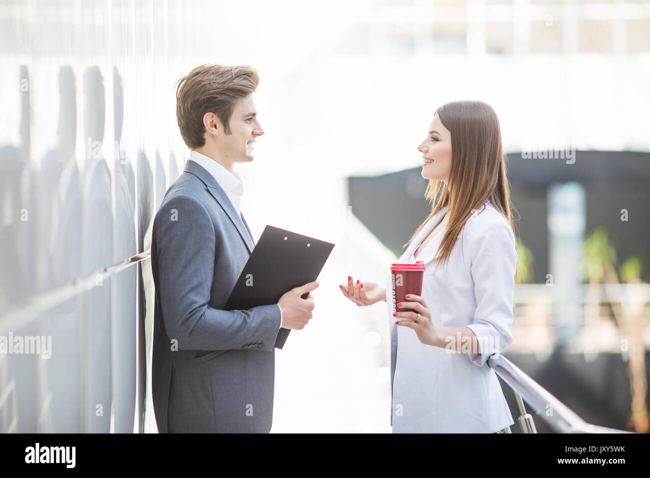 Two Business Colleagues Sitting Around Boardroom Table Having Informal ...