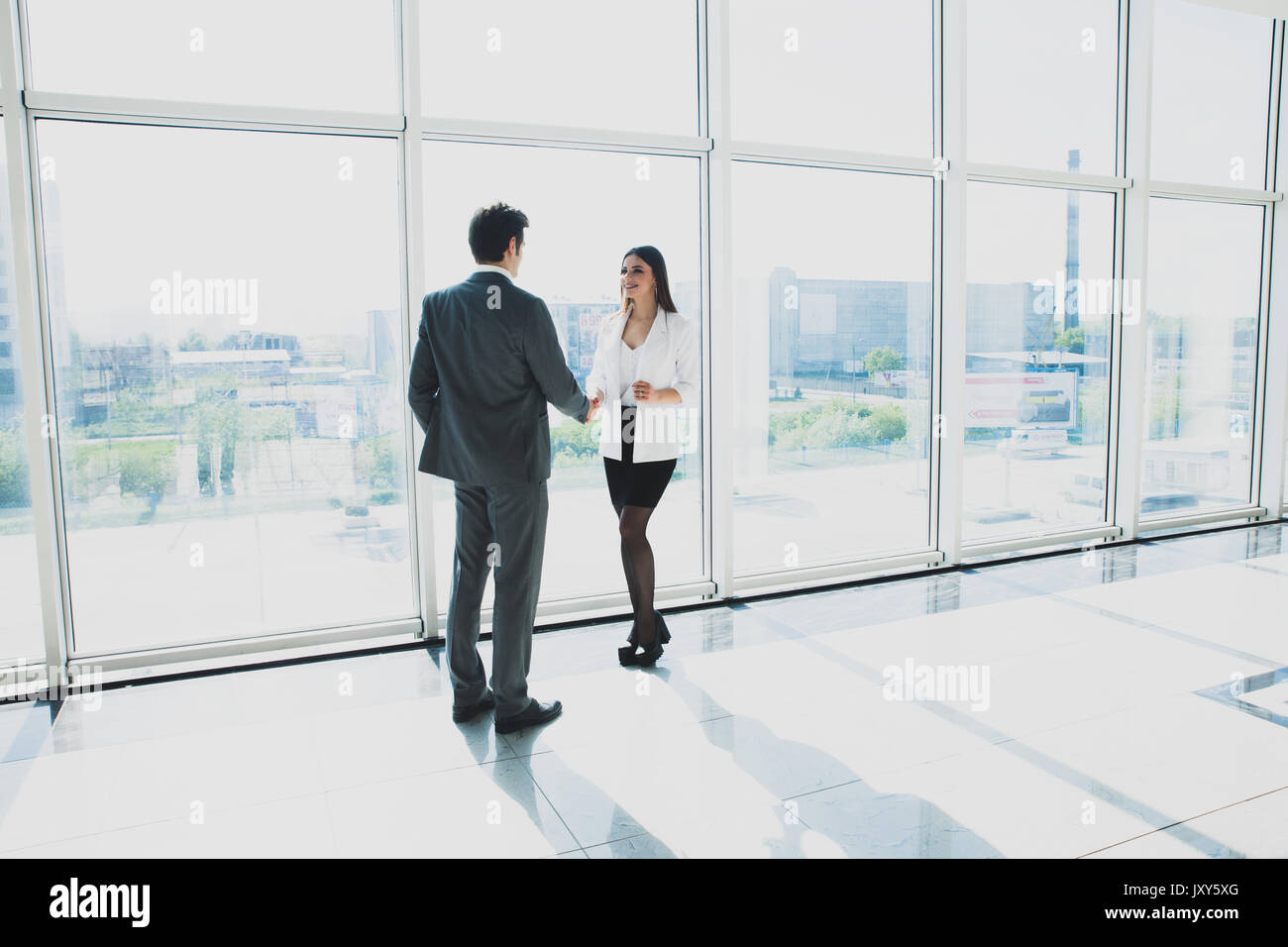 View from below of two young businessmen are standing in modern office ...