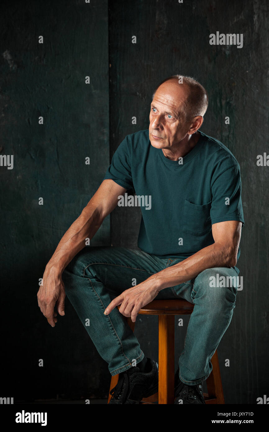 Worried mature man sitting at studio Stock Photo - Alamy