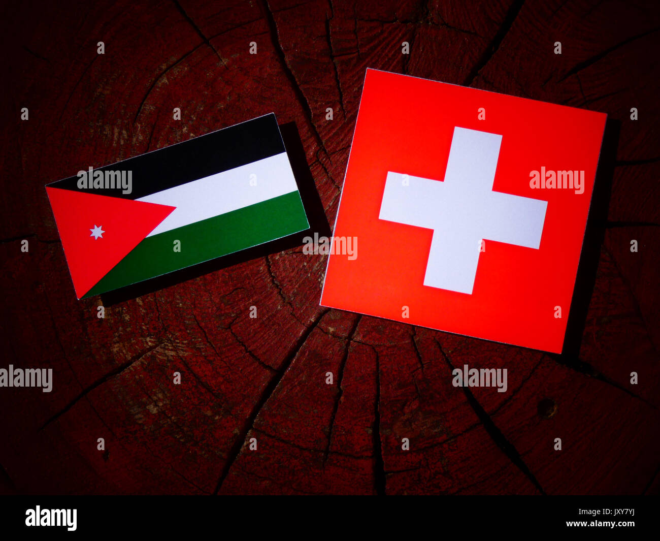 Jordanian flag with Swiss flag on a tree stump isolated Stock Photo - Alamy