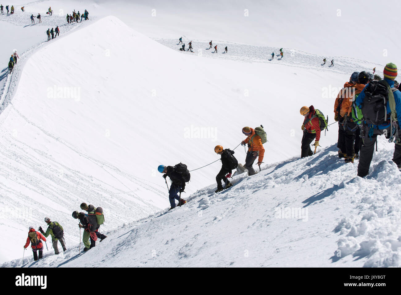 Climbers roped together on their way to the Aiguille du Midi mountain ...