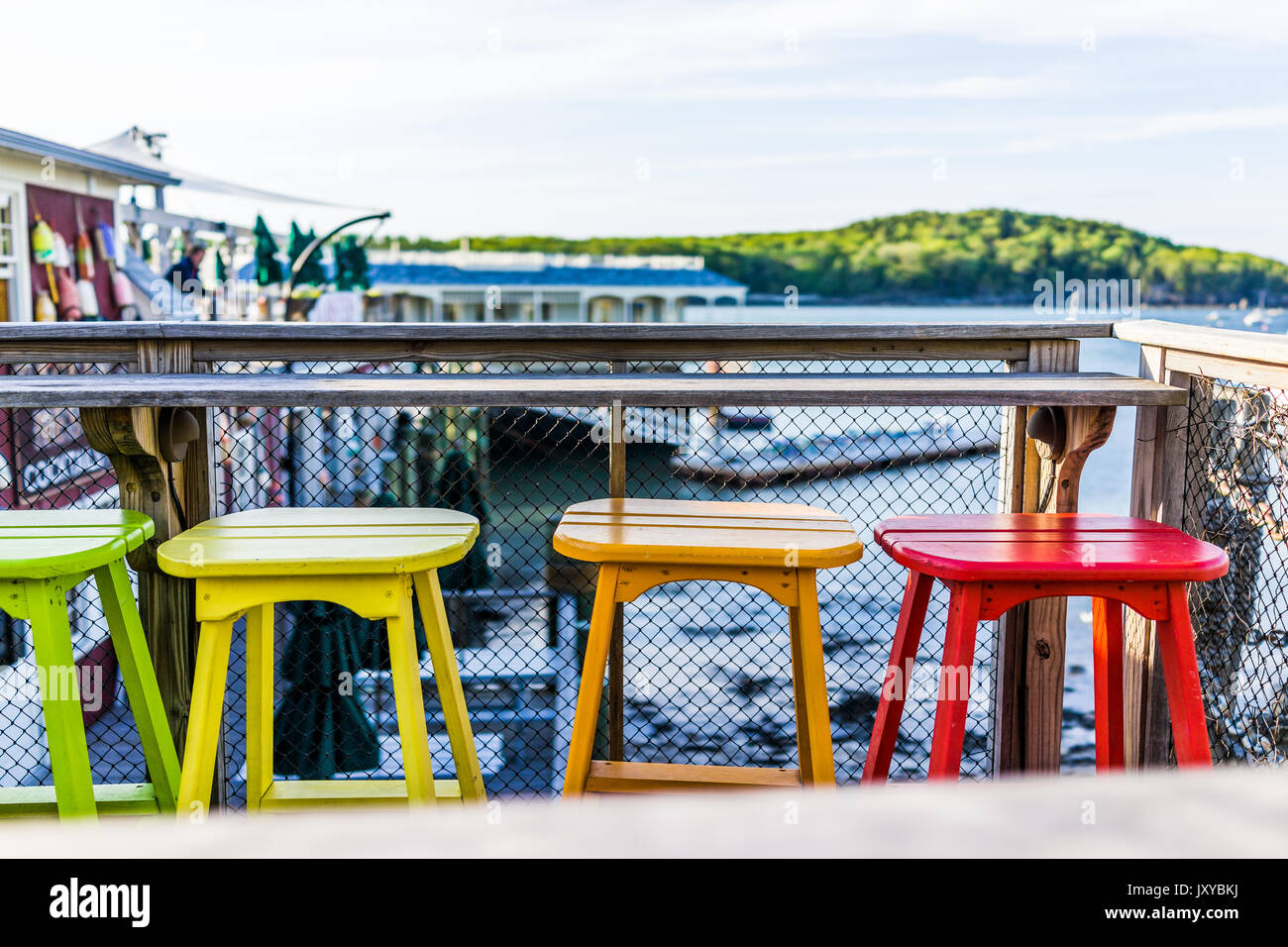 Colorful vivid chairs painted green, yellow and orange on waterfront ...