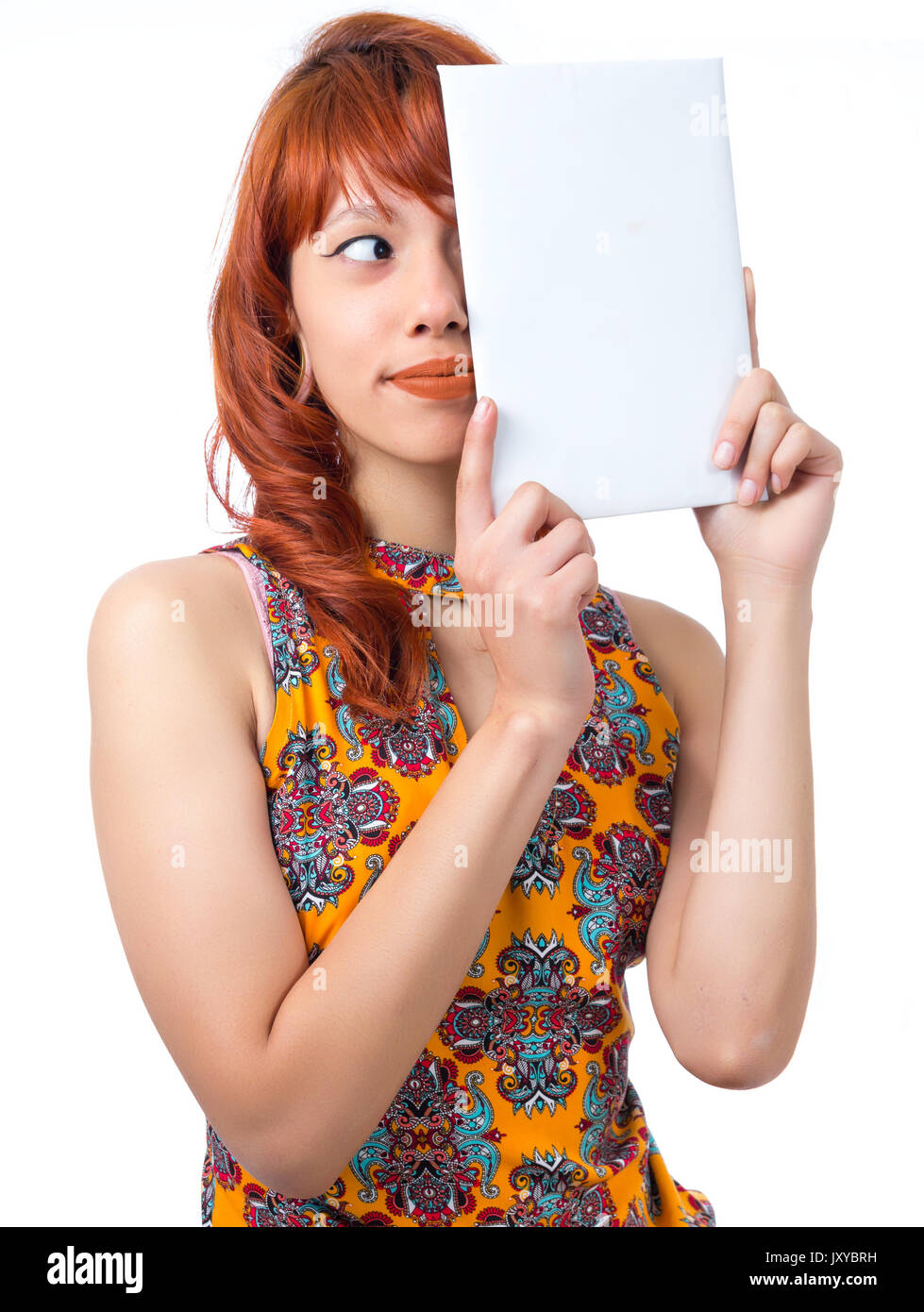 Woman is playing with the paper, covering part of the face. Redhead ...