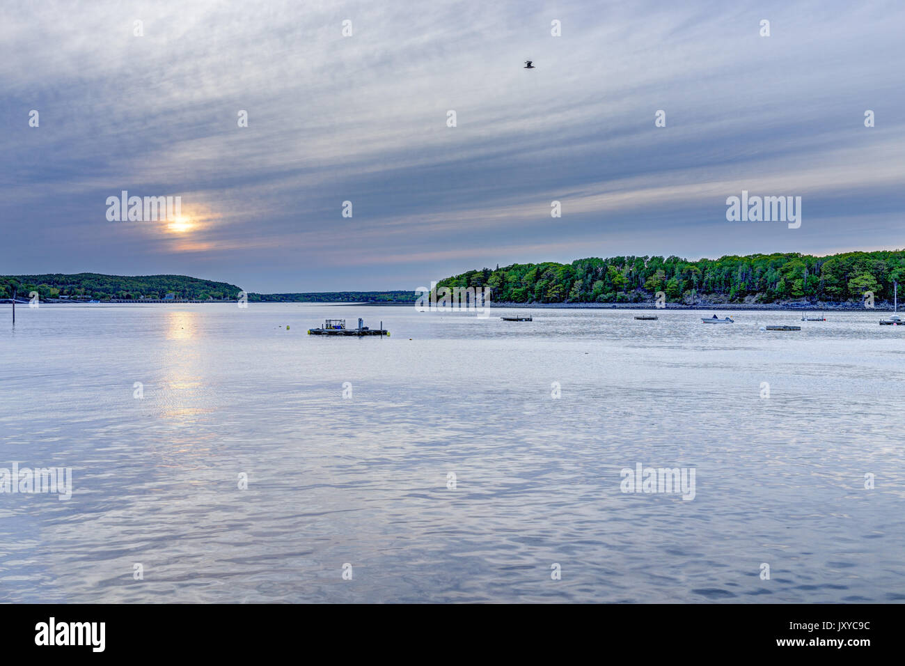 Sunset sun path in Bar Harbor, Maine village with empty boats in water ...