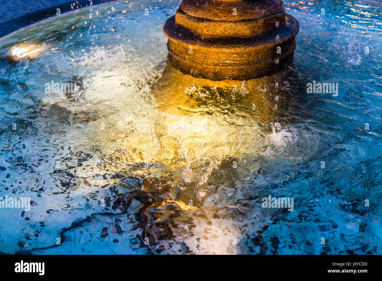 Closeup of splashing water fountain in downtown village park during ...
