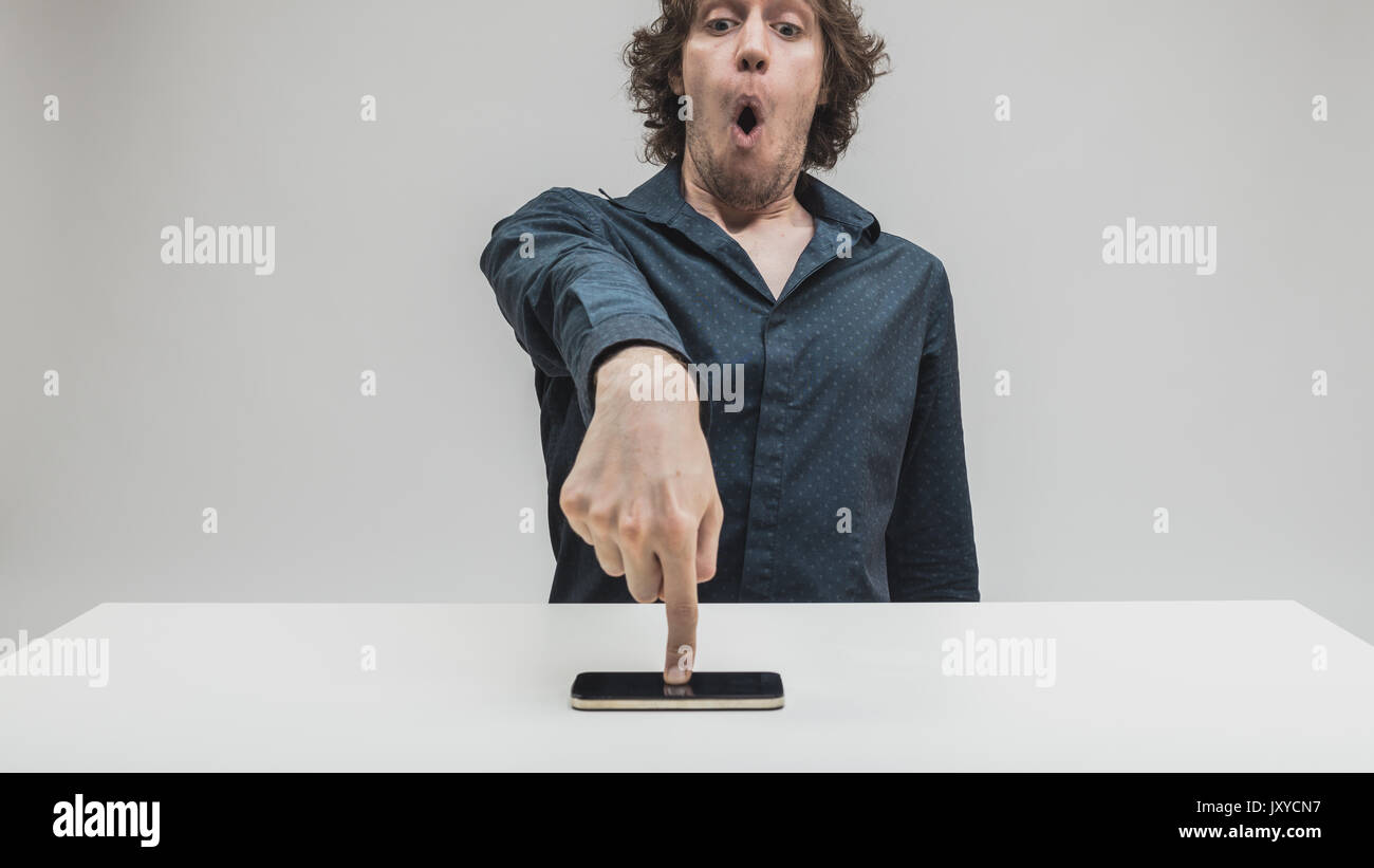 surprised man touching his smartphone screen - concept of fear of the ...