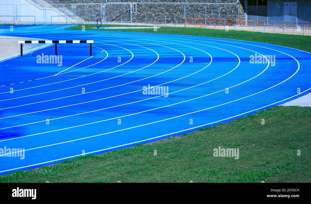 Blue athletic track in a stadium Stock Photo - Alamy