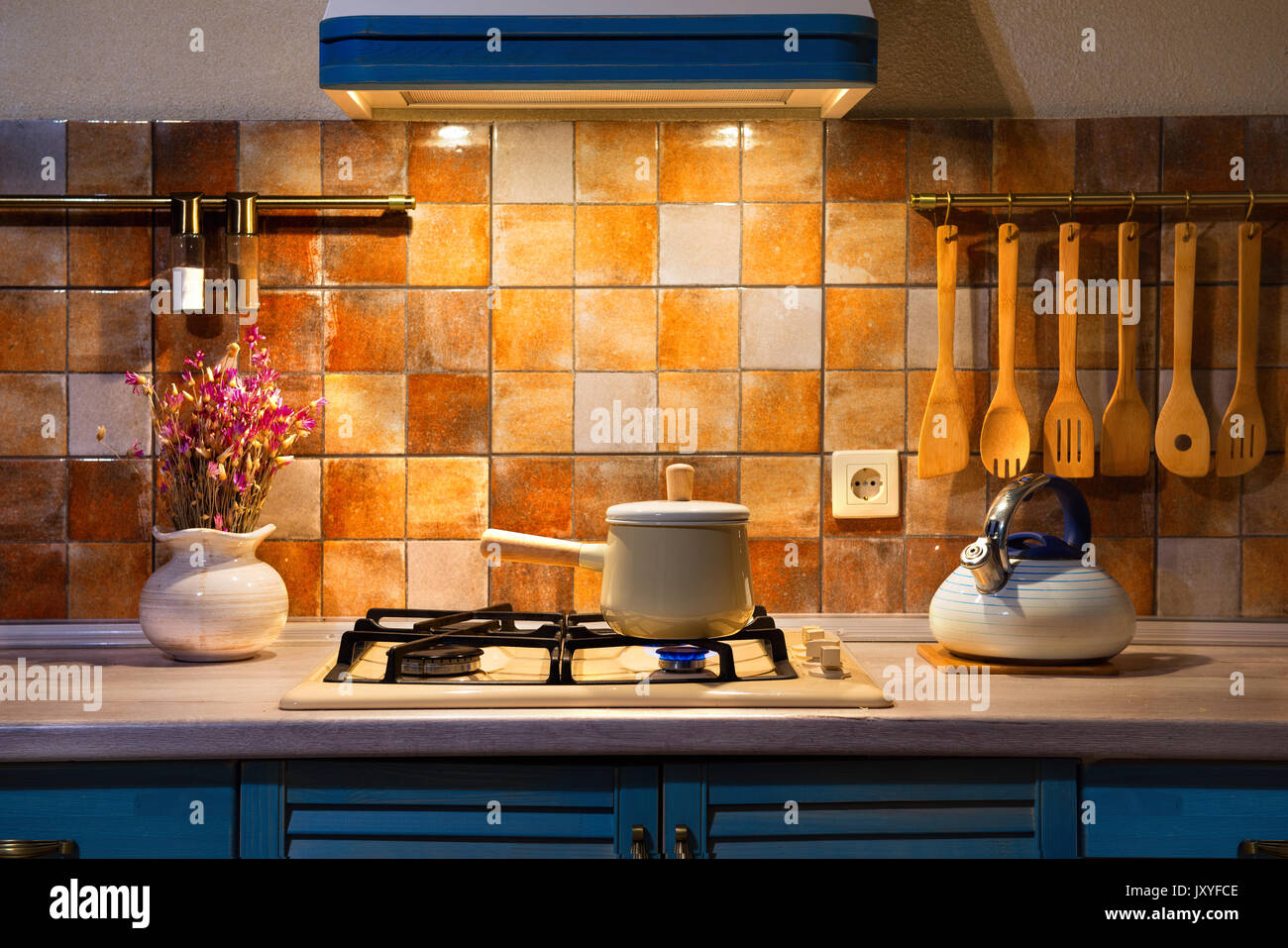 New pan with wooden handle on the stove. On fire Stock Photo - Alamy