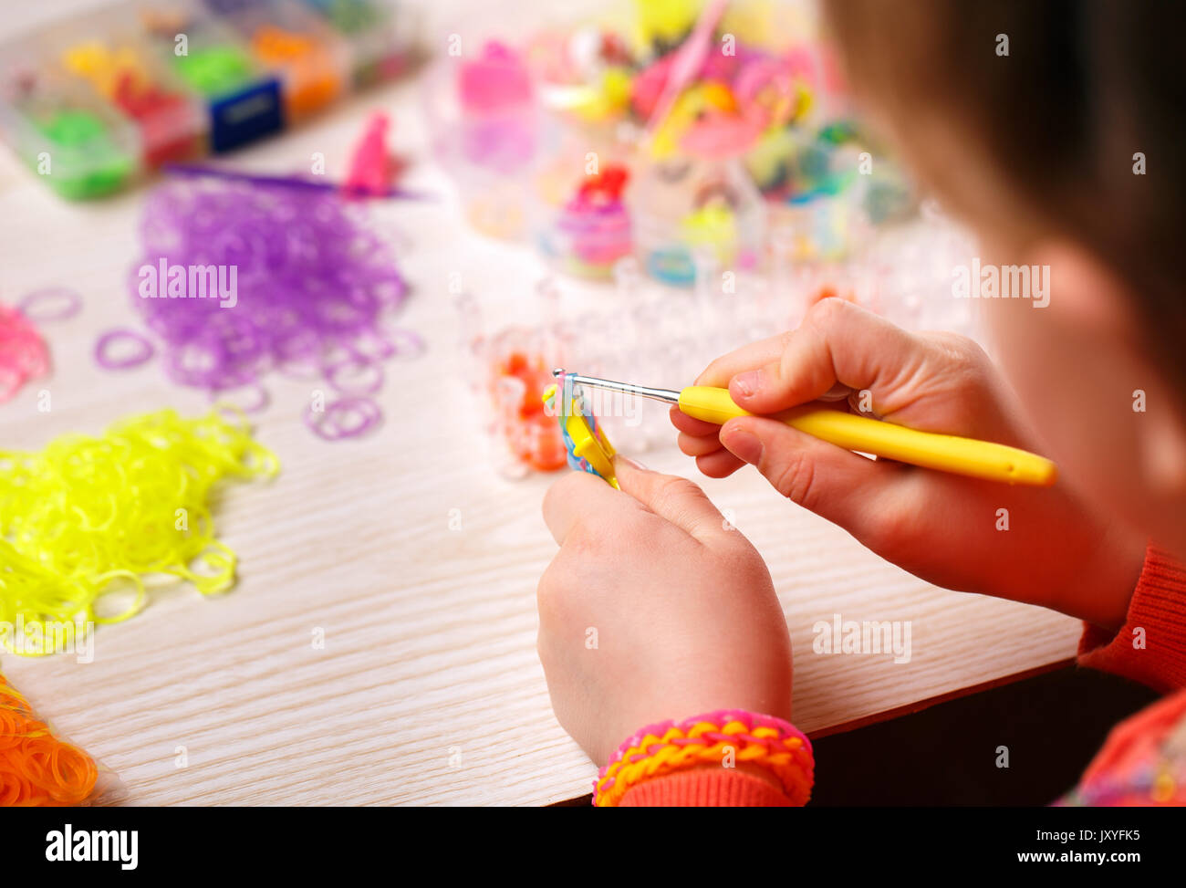 Handwork, weaving rubber, colored elastics on the table. Colored rubber ...