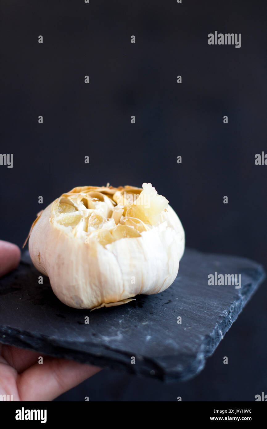 black plate of roasted garlic Stock Photo - Alamy