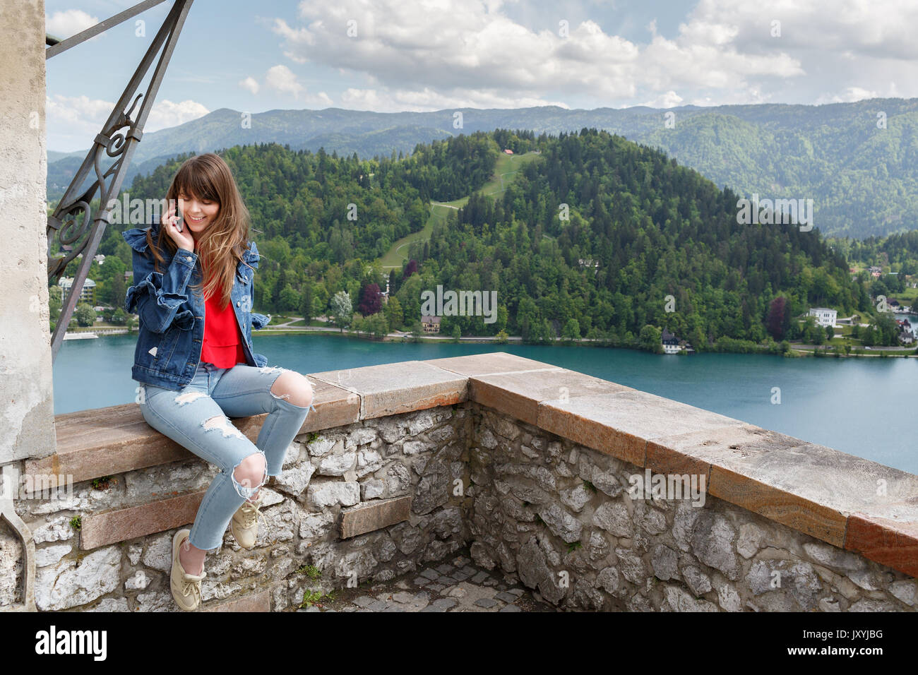 Girl talking on the phone from castle top of the mountain with valley ...