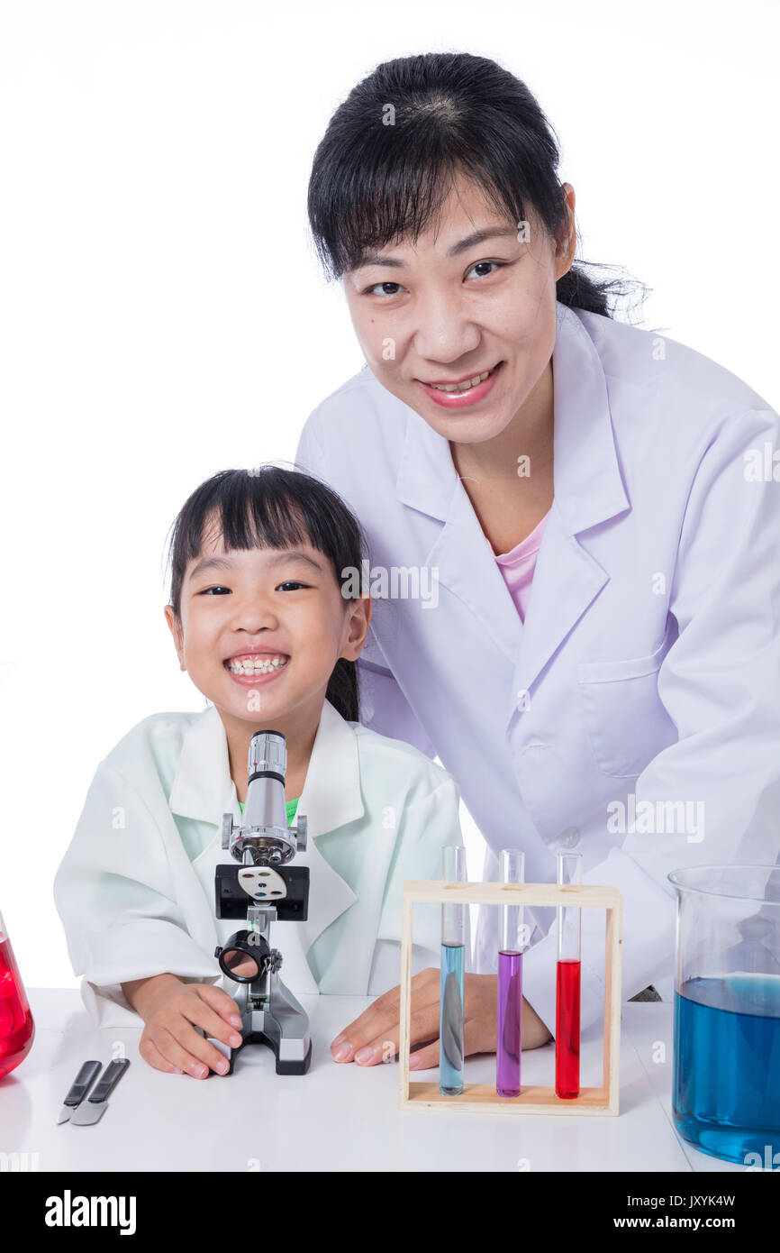 Asian Chinese teacher and little student girl working with microscope ...
