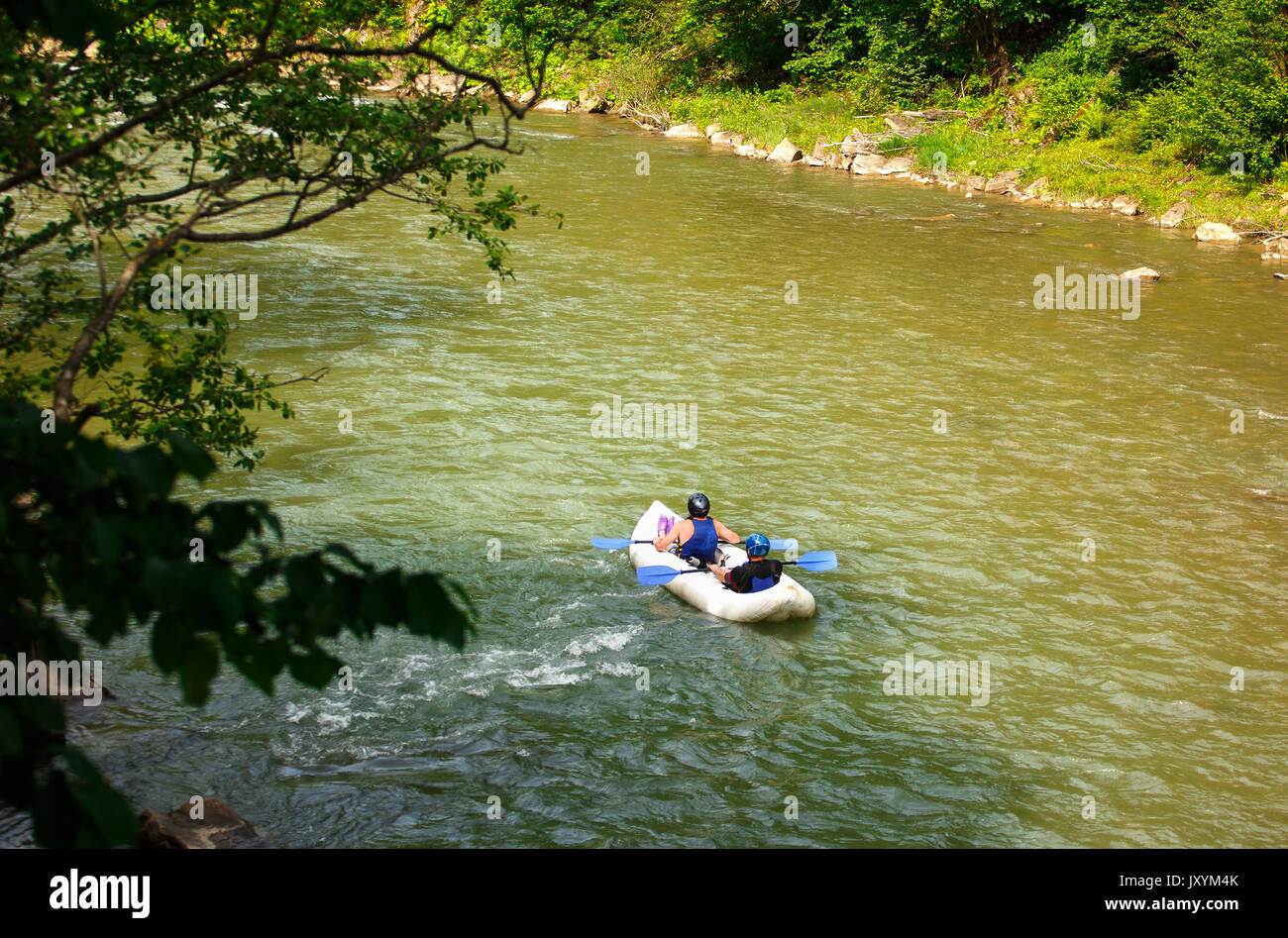 two people floating in a canoe with oars on a mountain river Stock ...