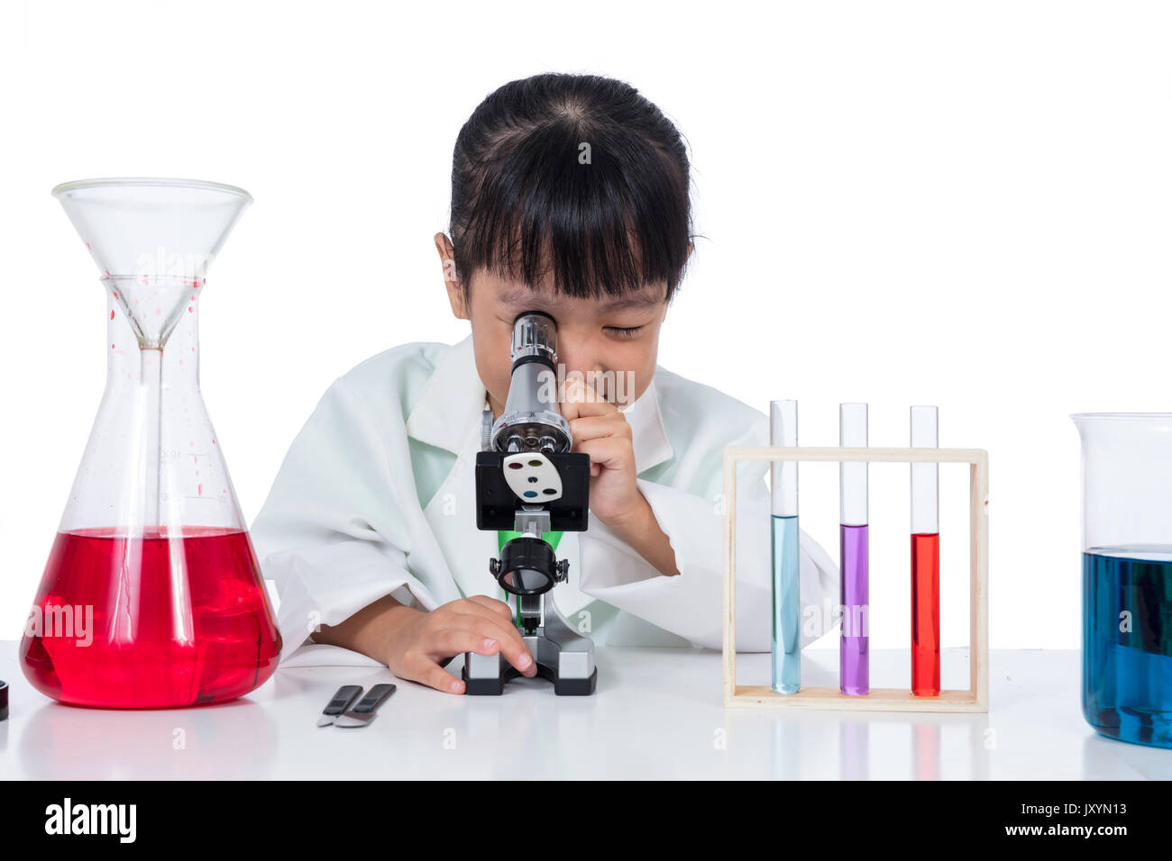 Asian Chinese little girl working with microscope in isolated white ...