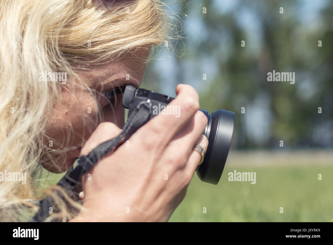 Professional woman photographer taking outdoor with prime lens, during ...