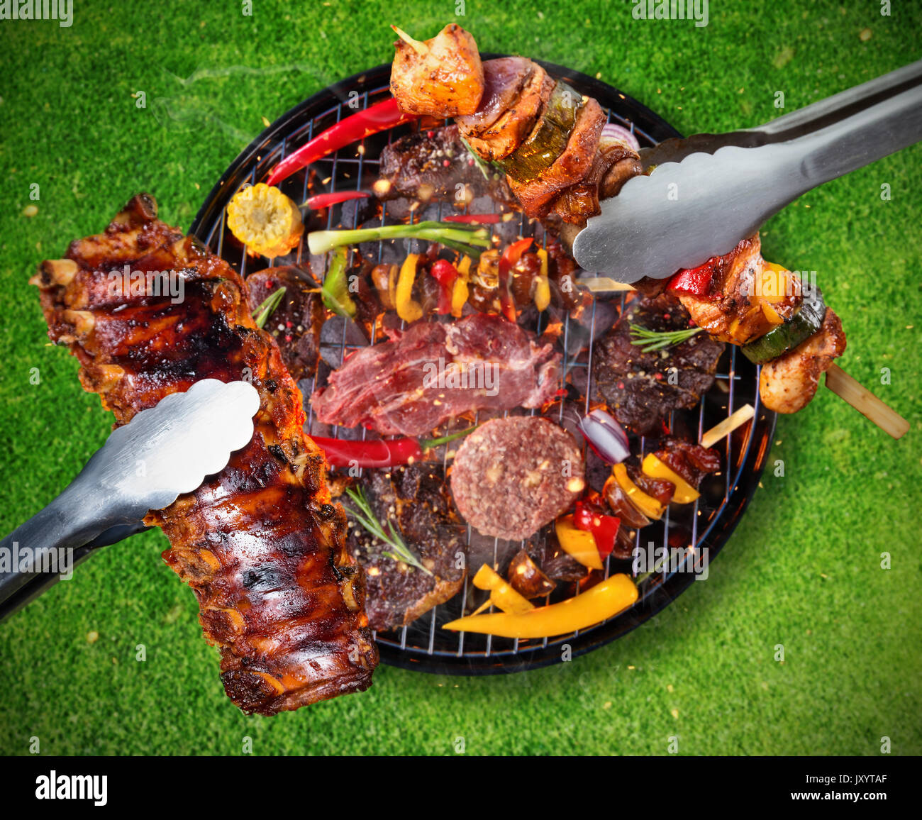 Top view of fresh meat and vegetable on grill placed on grass. Barbecue ...