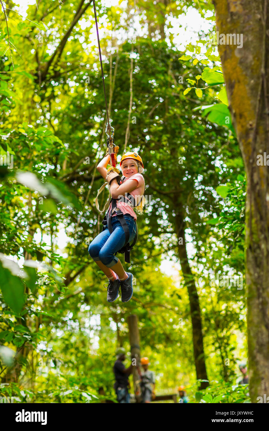 Caucasian girl hanging on zip line in forest Stock Photo - Alamy