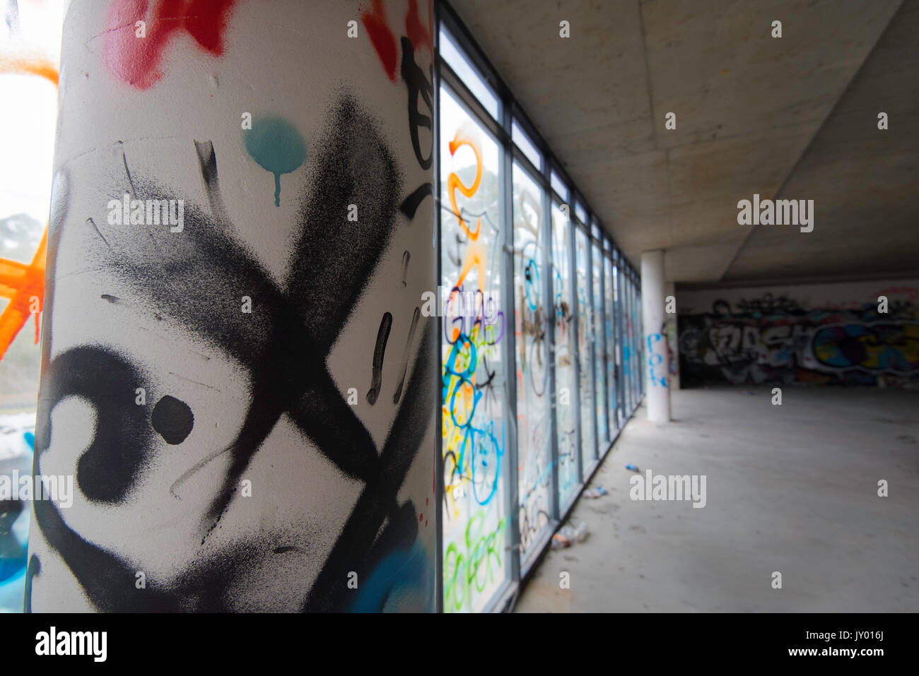 A spray painted and graffiti tagged window in an abandoned commercial ...
