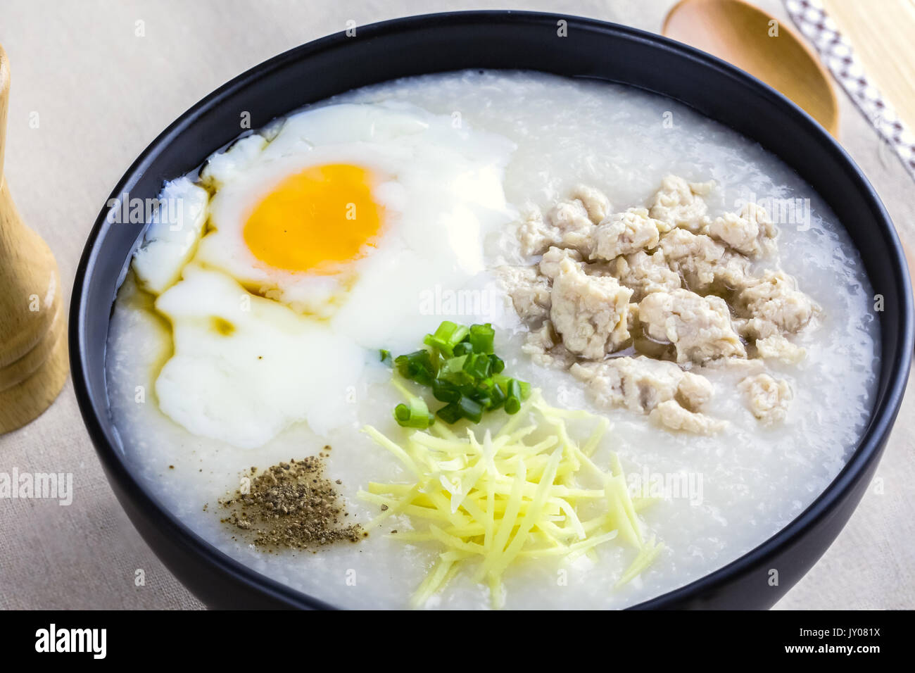 Rice porridge is topping with ginger, spring onion, pepper, chicken ...