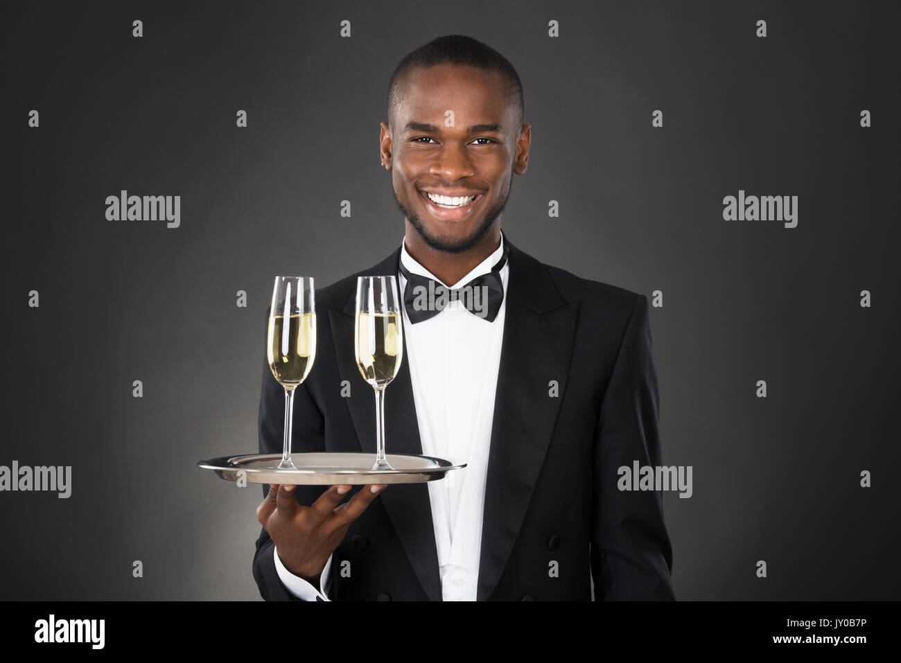 African Waiter Holding Champagne Drink Against Black Background Stock ...
