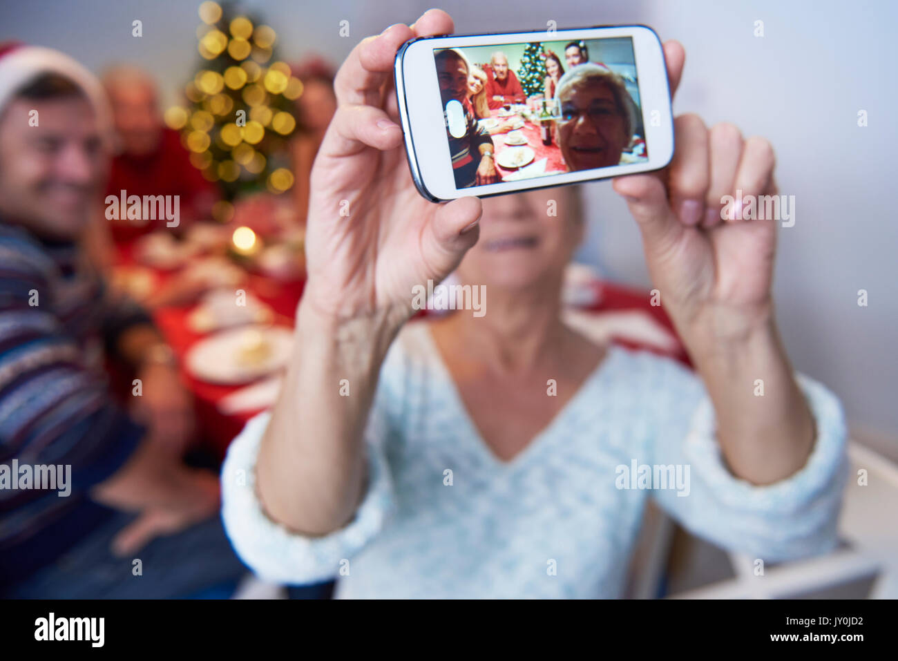 Modern grandmother taking a photo of the family Stock Photo - Alamy