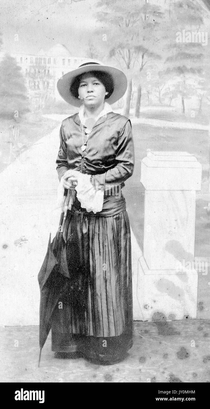 Full-body portrait of African American woman wearing a dark dress and a ...