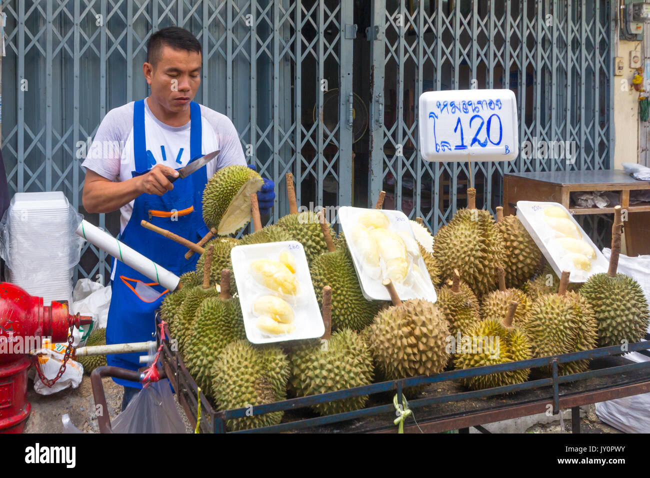 Durian vendor preparing durian fruit for sale, street market, Bangkok ...
