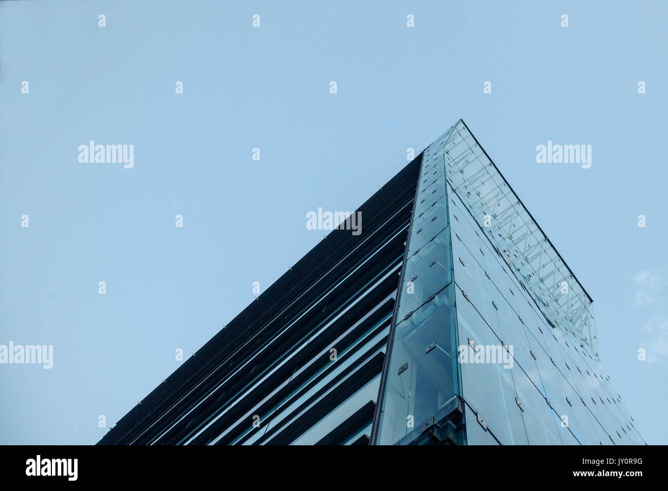 Corner of a skyscraper under a cloudy and cold sky seen from the bottom ...