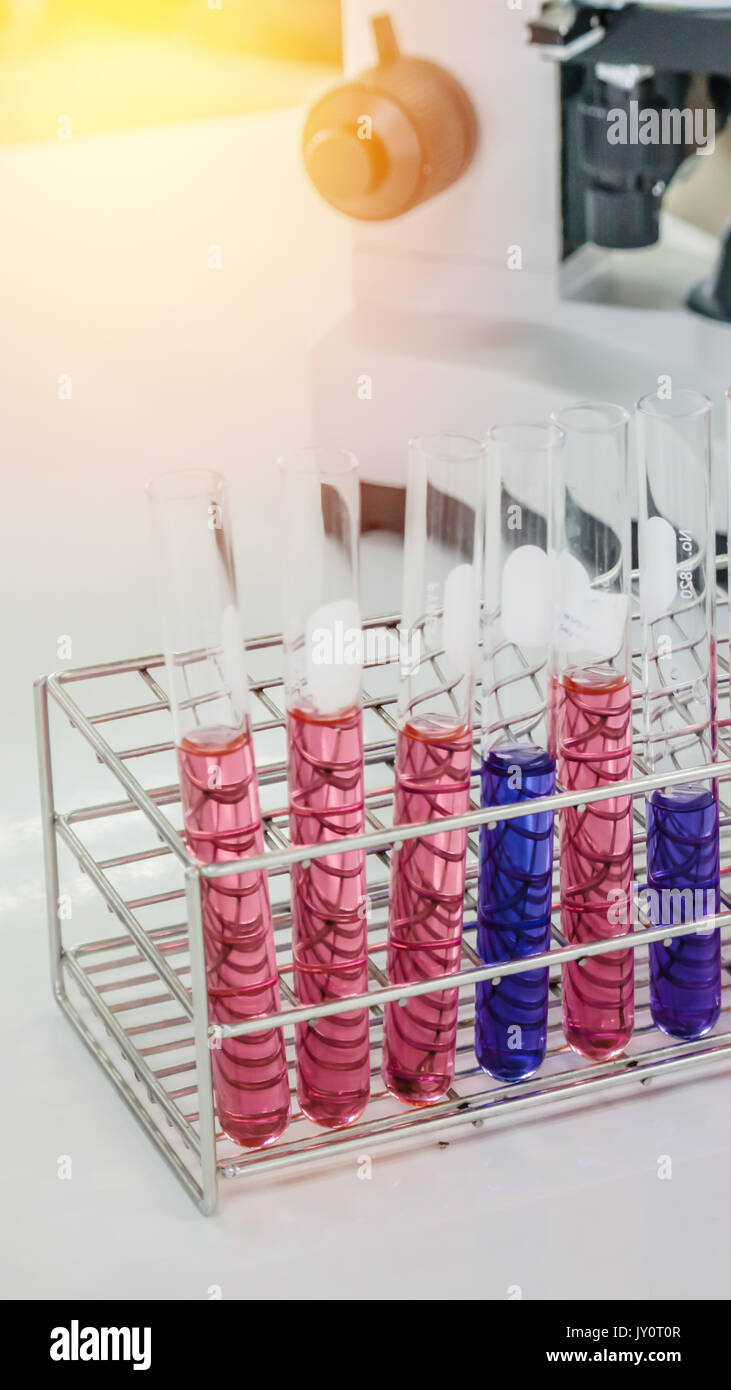 Different laboratory test tubes with colored liquid and with reflection ...