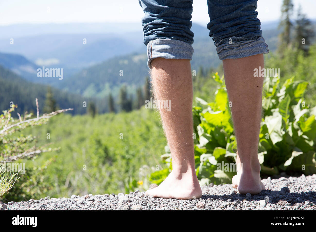 Barefoot Caucasian man standing near mountain landscape Stock Photo - Alamy