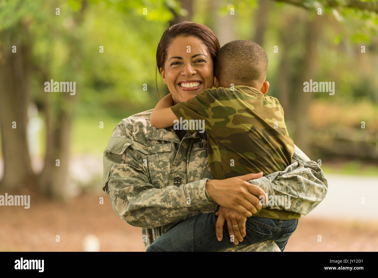 African American soldier mother carrying and hugging son Stock Photo ...