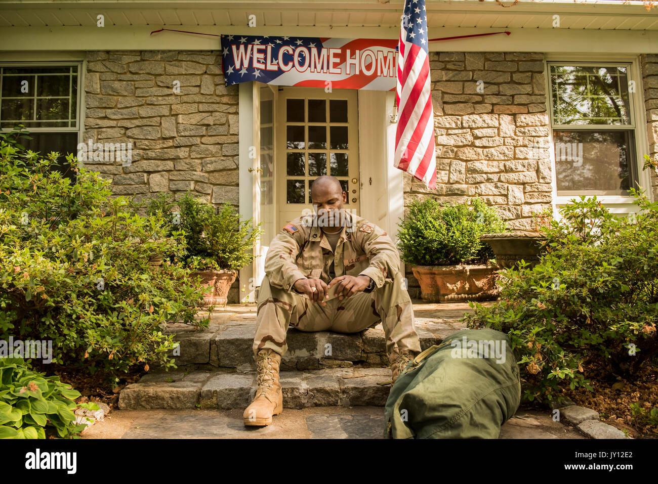 Frustrated African American soldier sitting on front stoop Stock Photo ...
