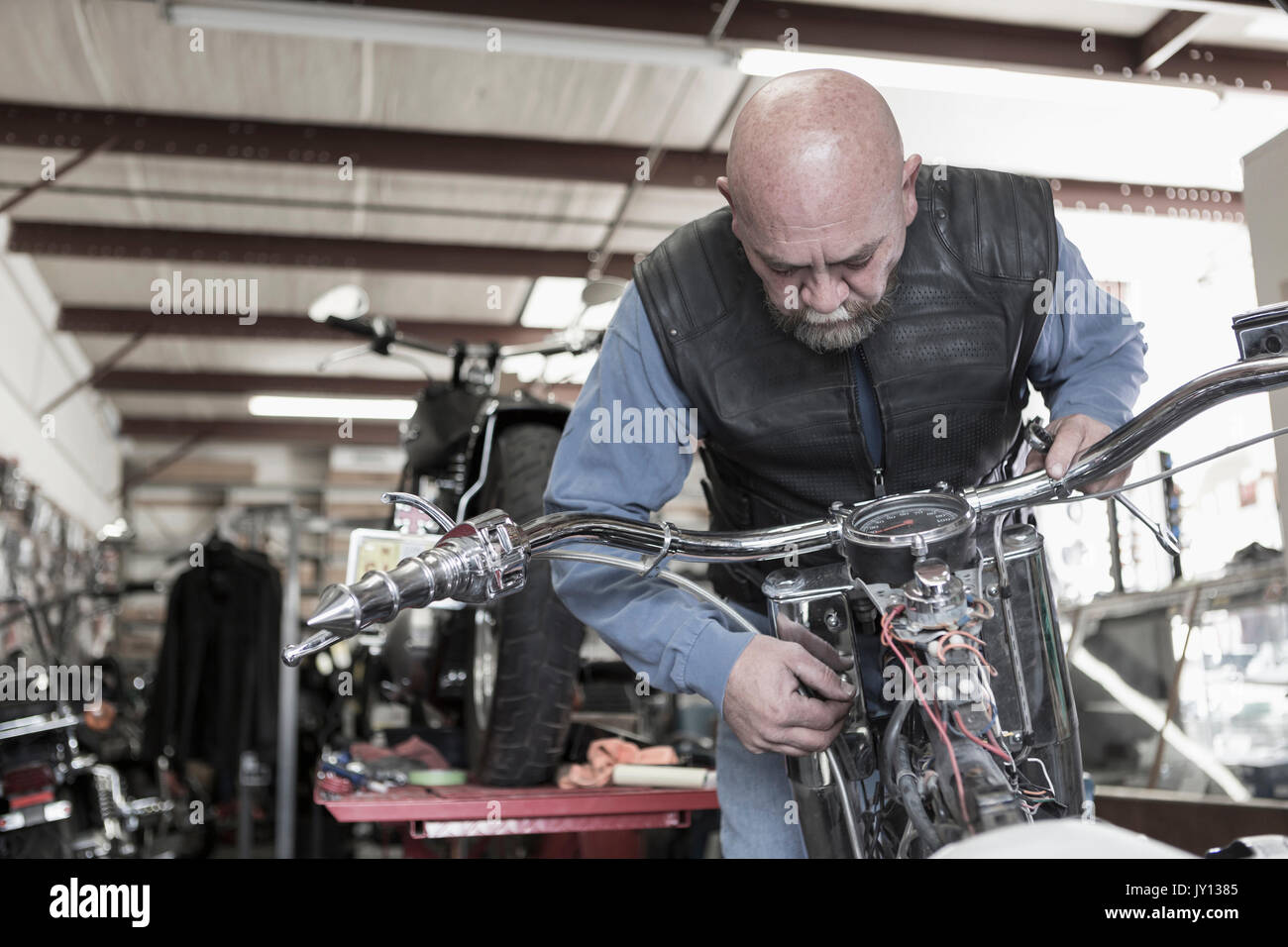 Caucasian man repairing motorcycle Stock Photo - Alamy