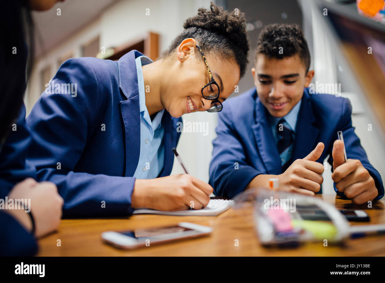 Teen students are working together and taking notes in lesson time at ...