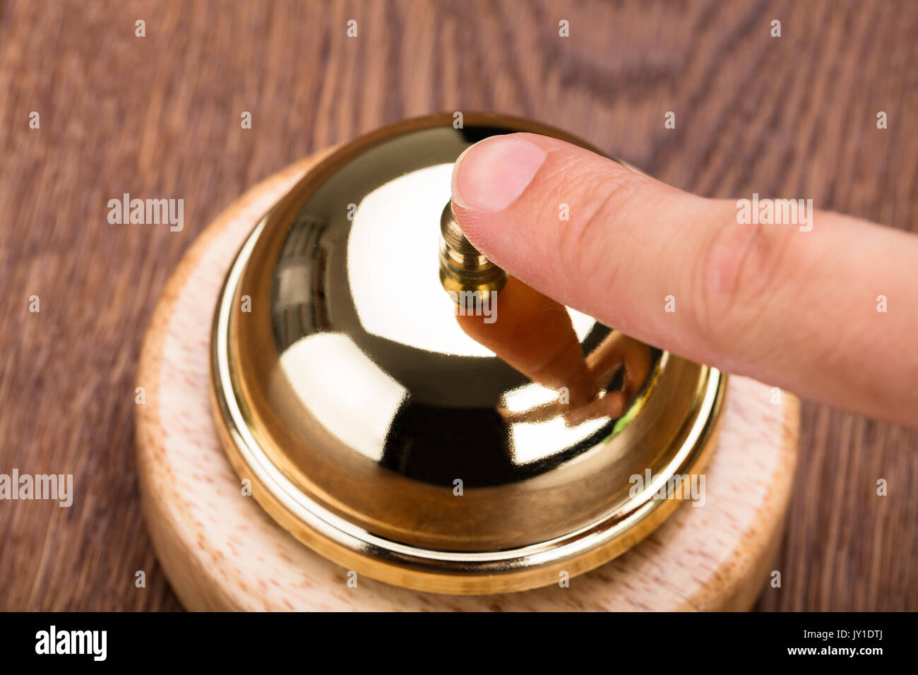 High Angle View Of Person Ringing Service Bell On Wooden Desk In Hotel ...