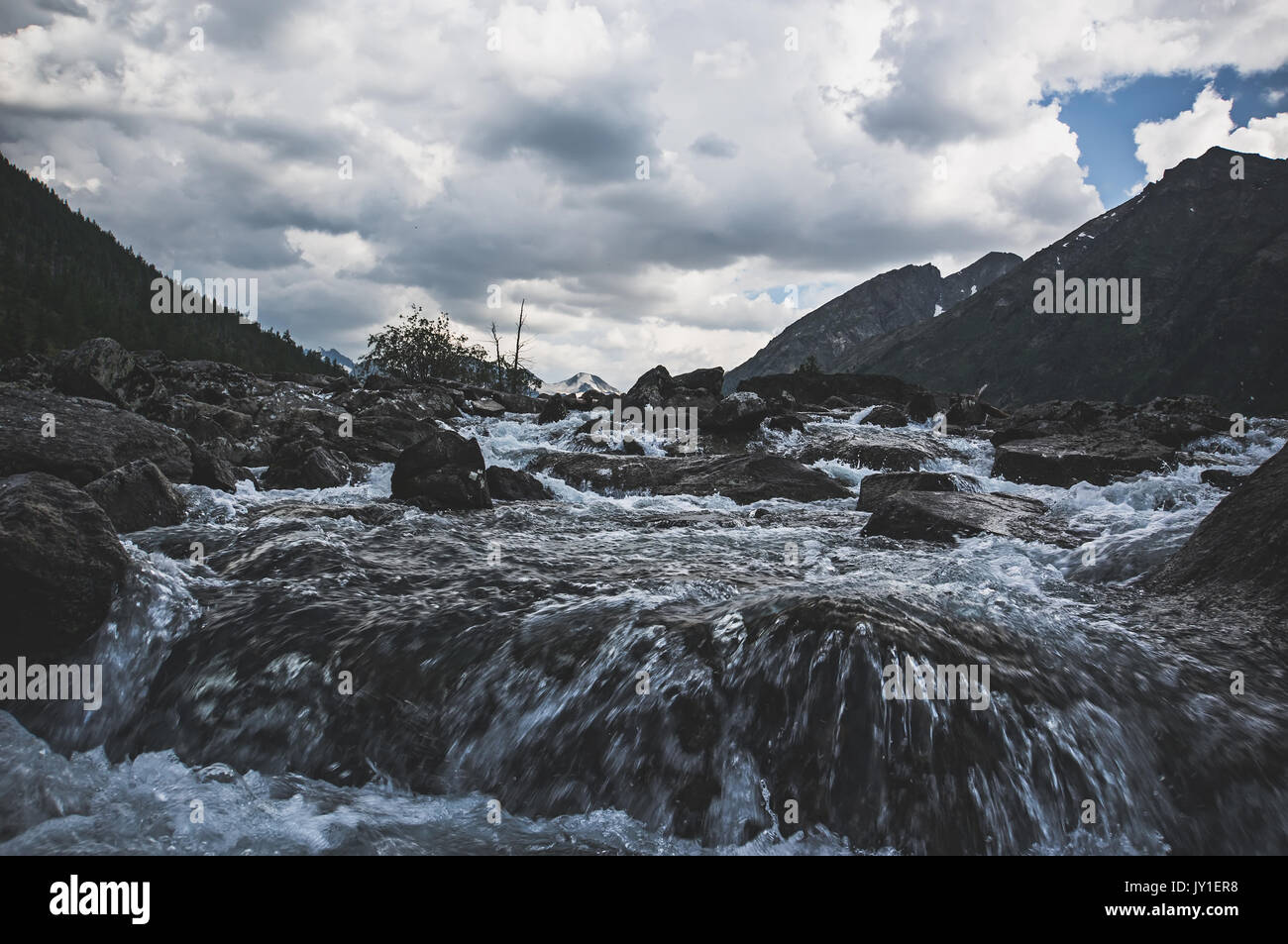 Dark gloom mountain valley along the mountain river on the background ...