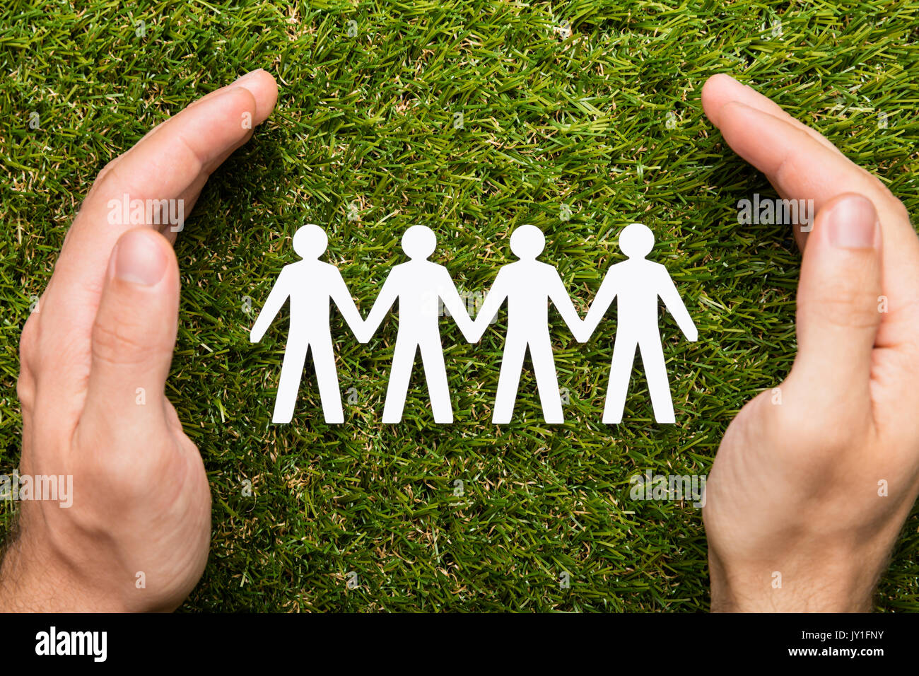 High Angle View Of Person Hand Protecting Papercut On Grass Stock Photo ...