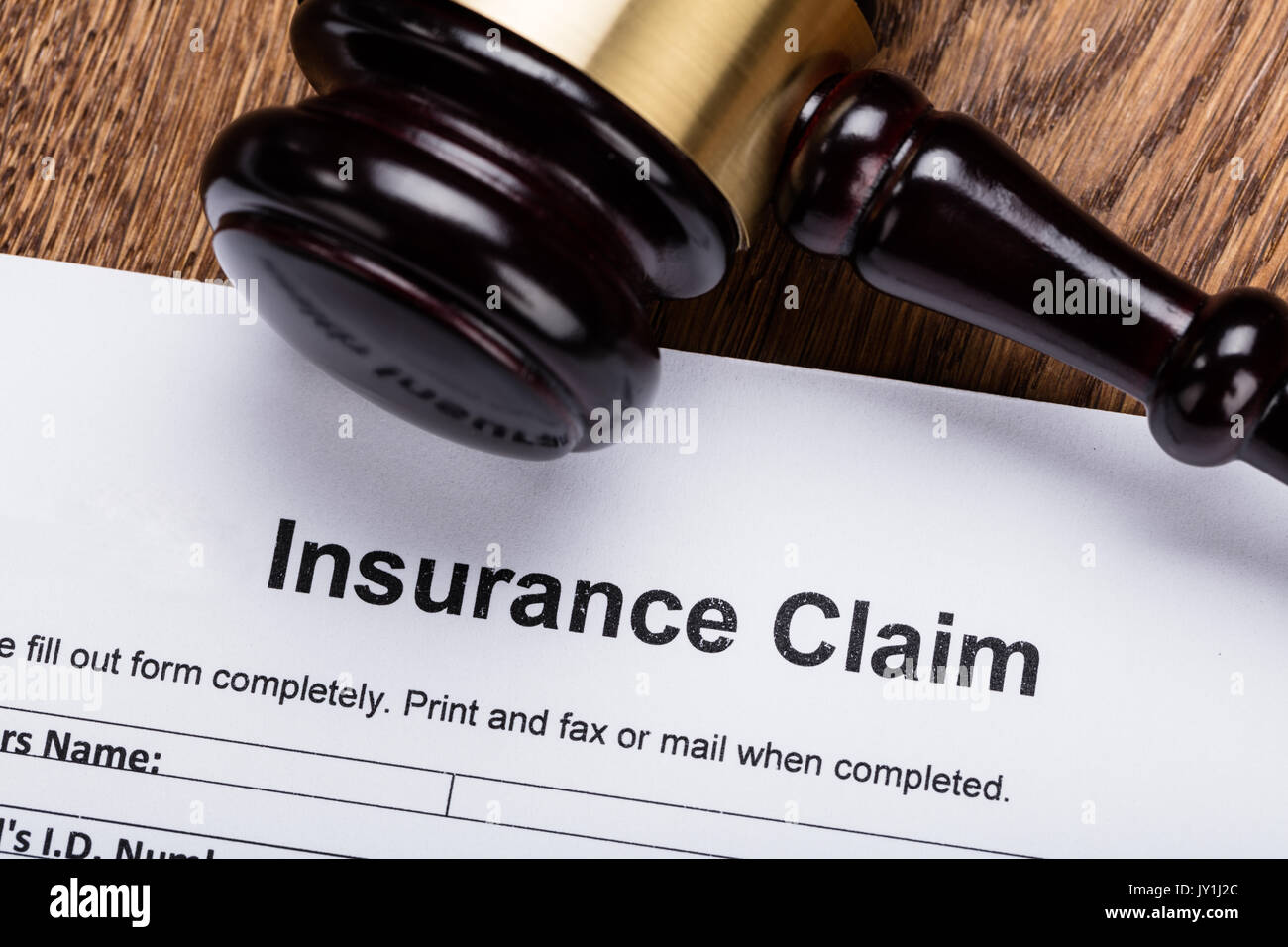 Close-up Of Wooden Gavel On Insurance Claim Form At Wooden Desk Stock ...