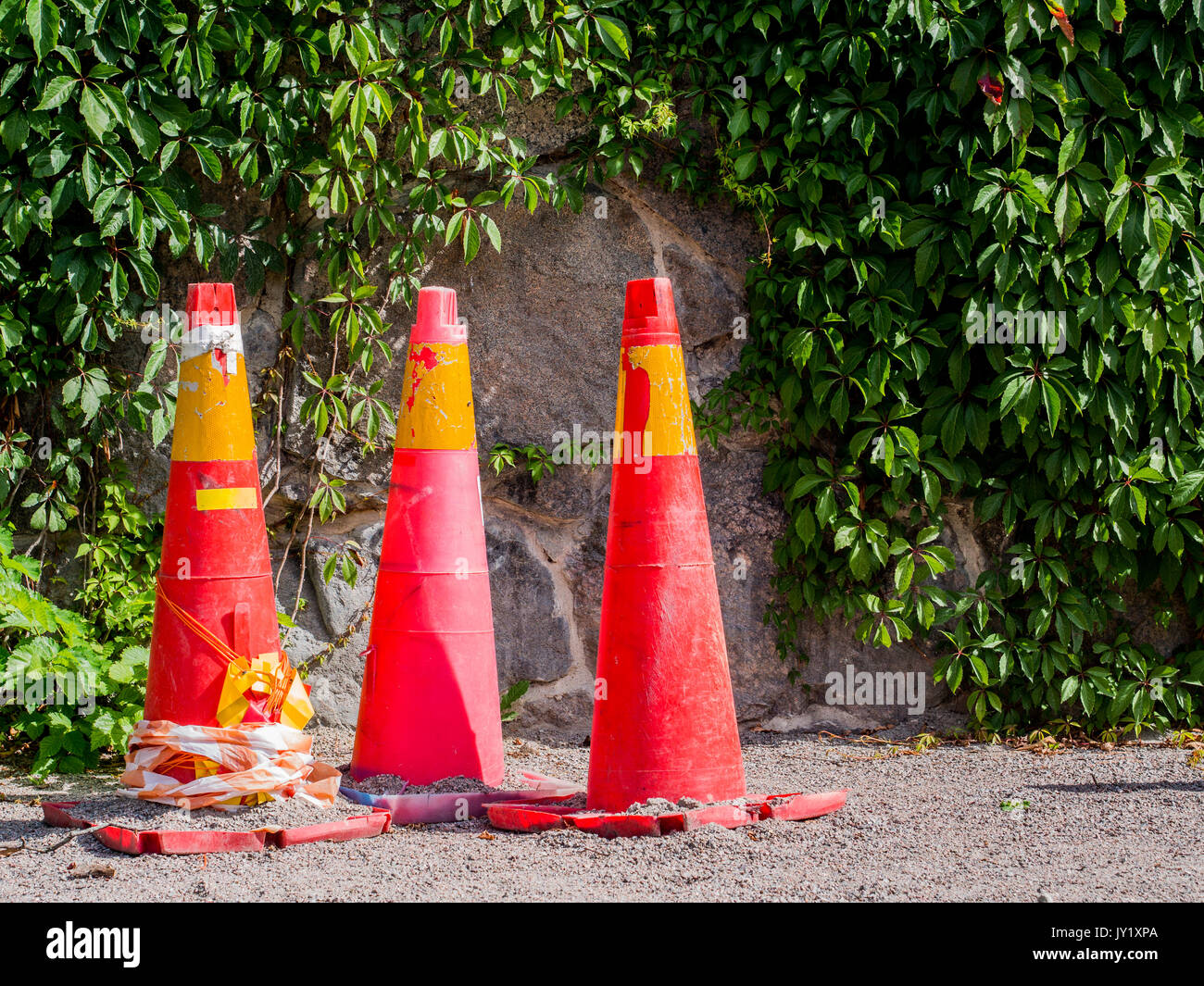 Traffic cones by a leaf covered stone wall Stock Photo - Alamy