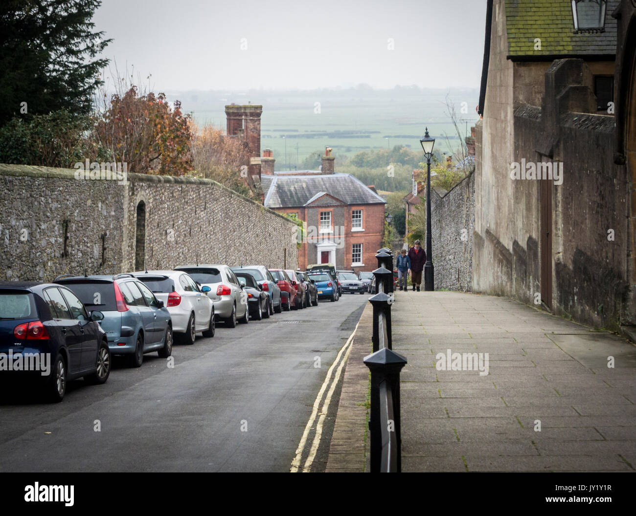Street view looking downhill with people walking uphill on the pavement ...