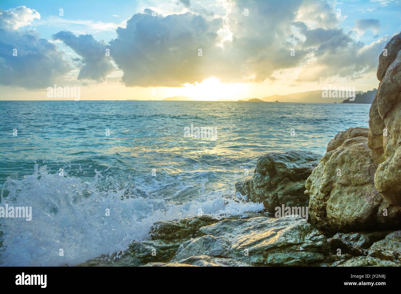 Splash waves hit rocks with the beautiful sunset and sky Stock Photo ...