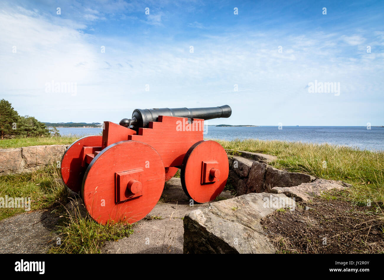 Red cannon standing at Odderoya, Kristiansand, Norway. View to the sea ...